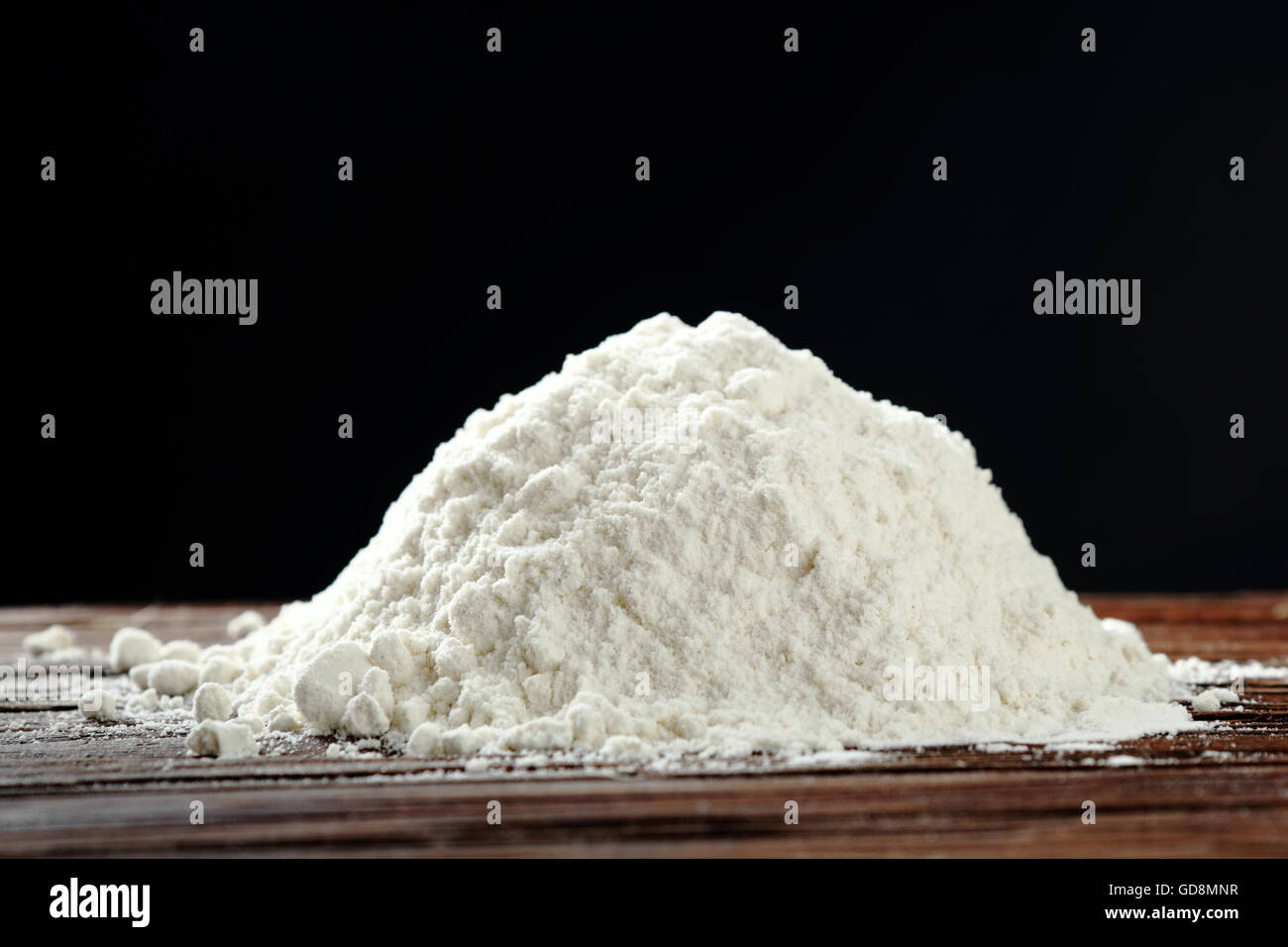 Pile of flour at black background Stock Photo - Alamy