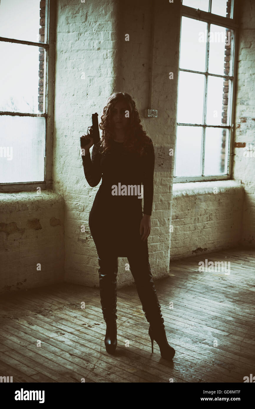 Woman holding a gun by the window Stock Photo - Alamy