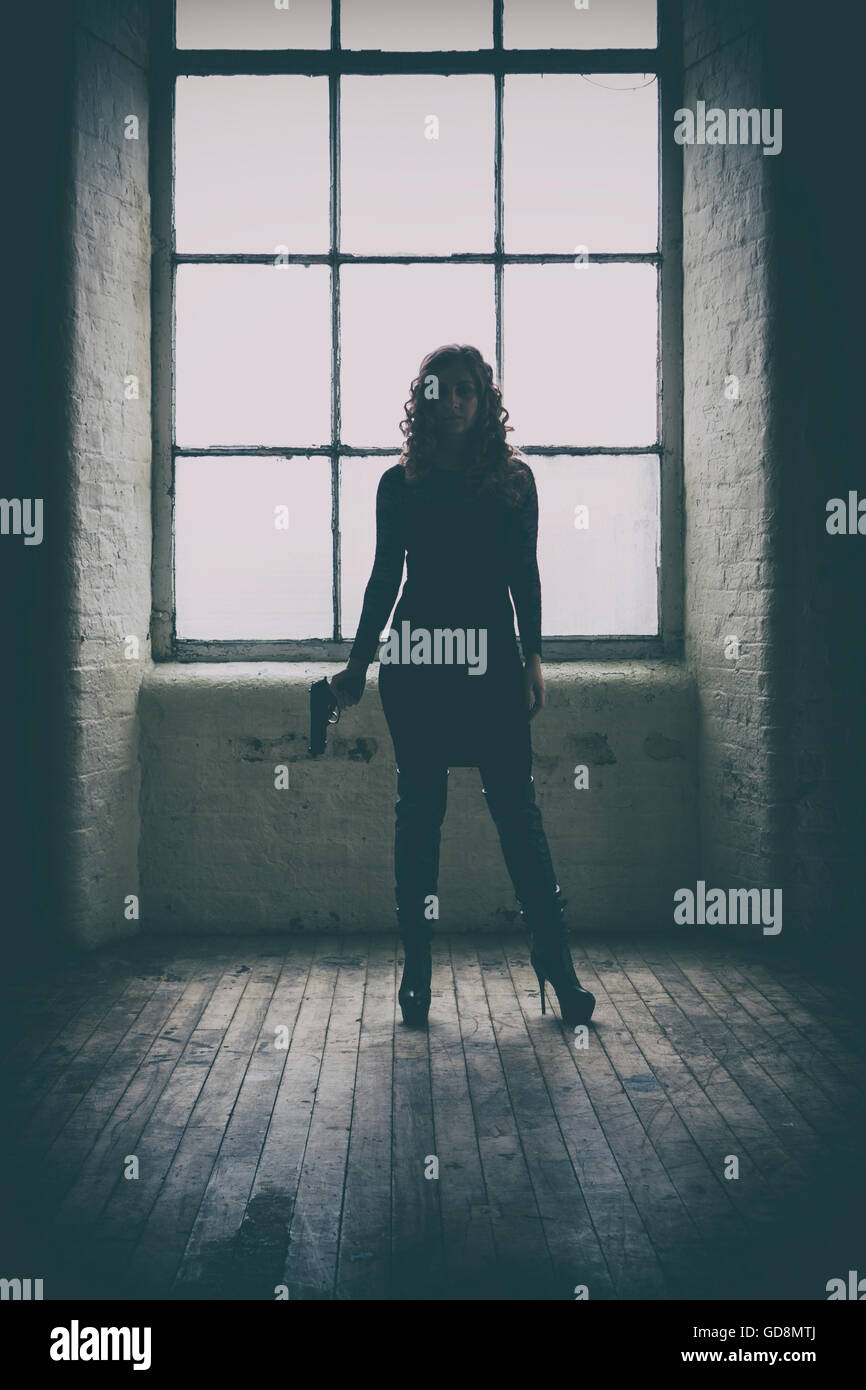 Woman holding a gun by the window Stock Photo - Alamy