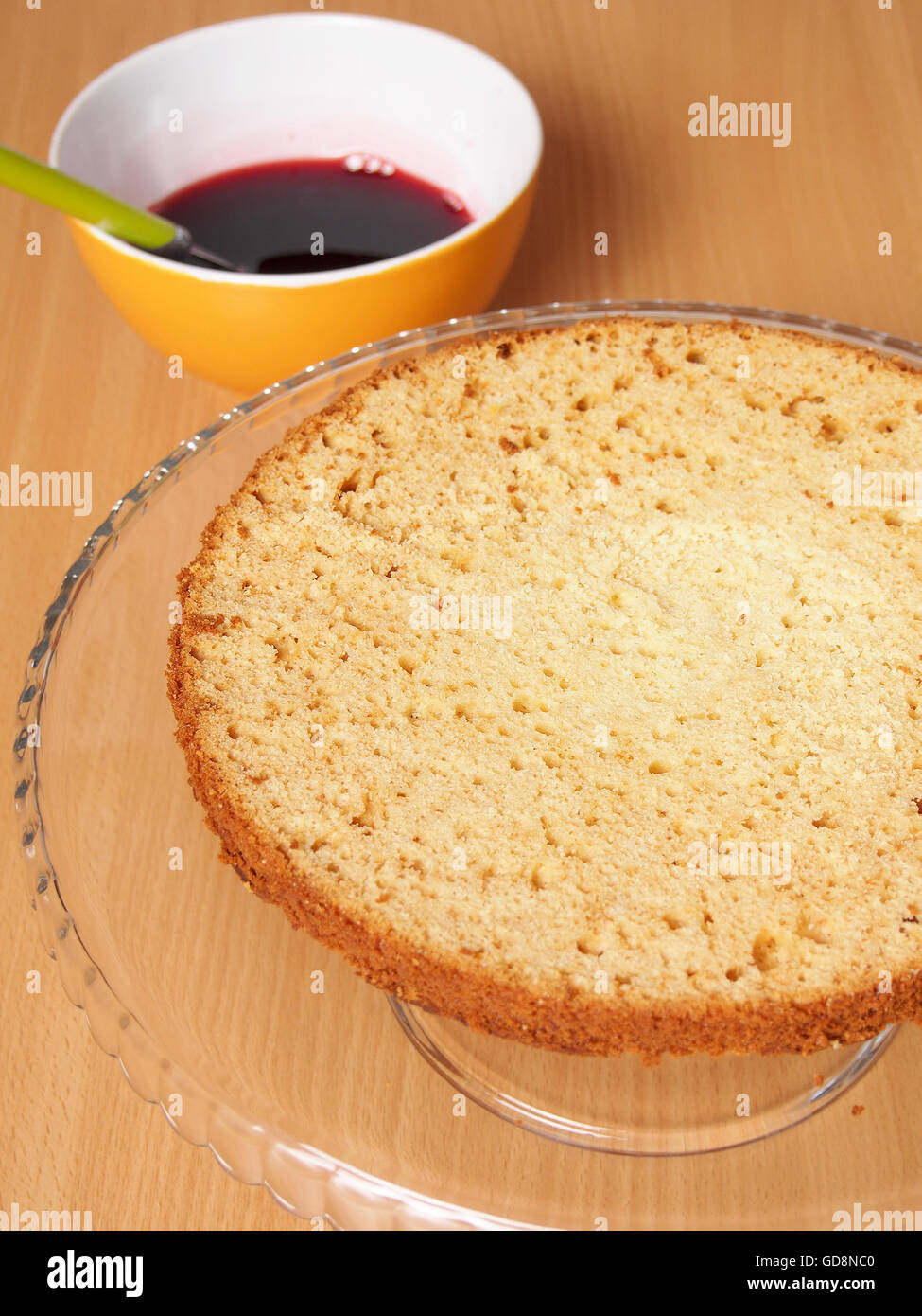 Spreading cake layer with jam. Making torte with buttercream filling ...