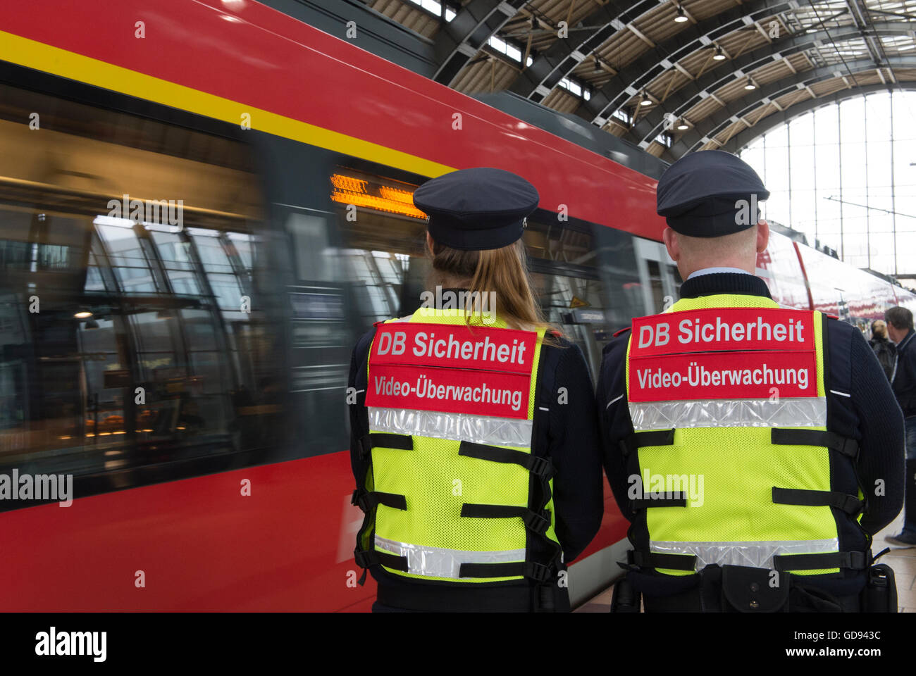 Security guards from the Deutsche Bahn walk wearing special vests ...