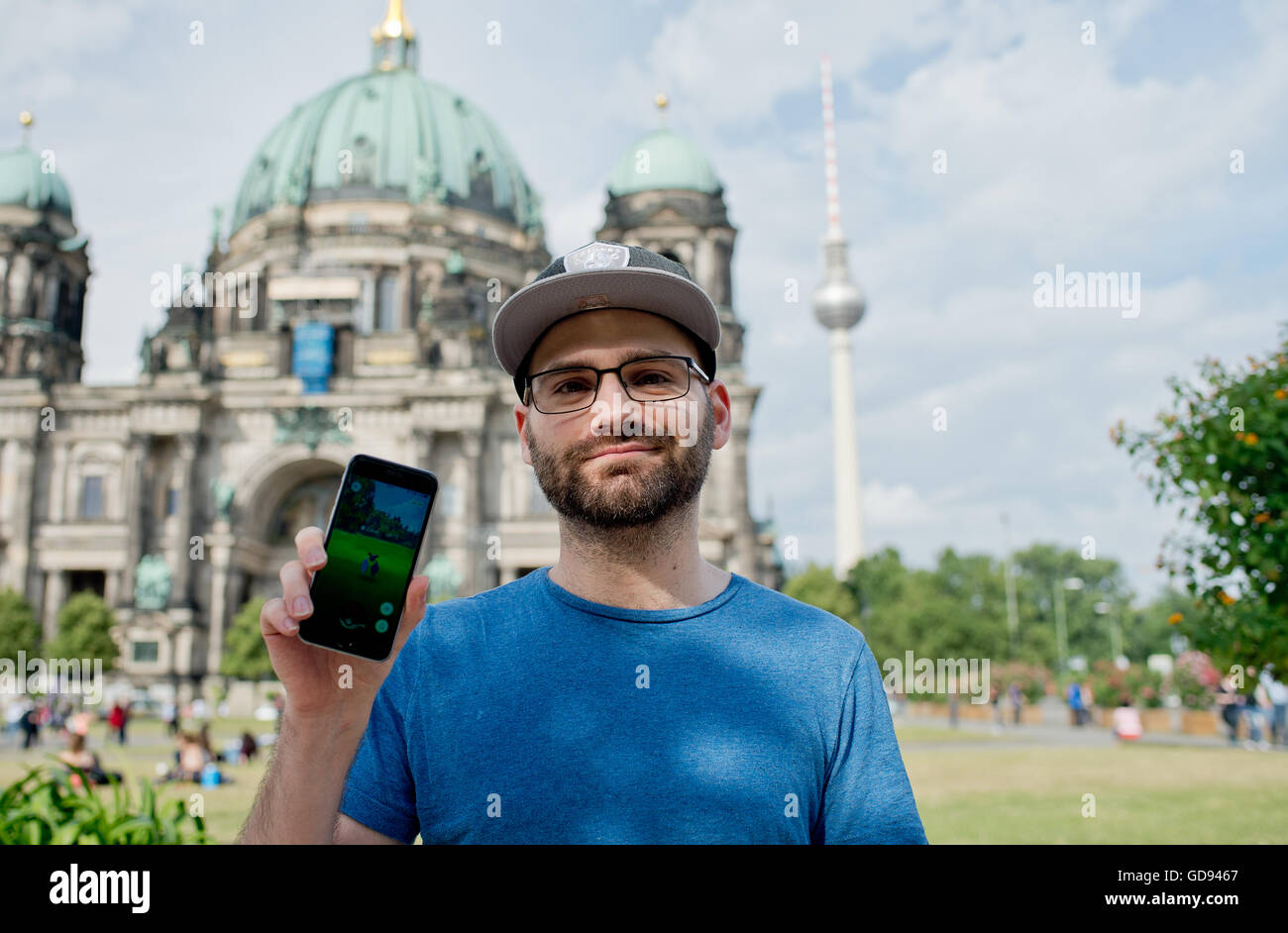 The 'Pokemon Go' player Aaron Schellhaas holds up his smartphone, which ...