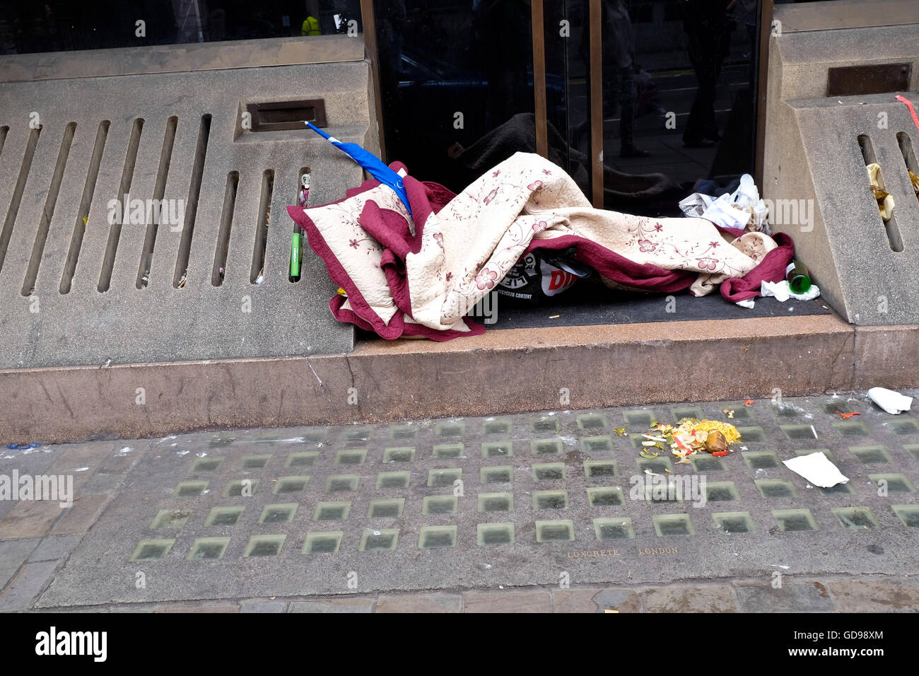 A homeless persons blanket and litter on the pavement in London Stock ...
