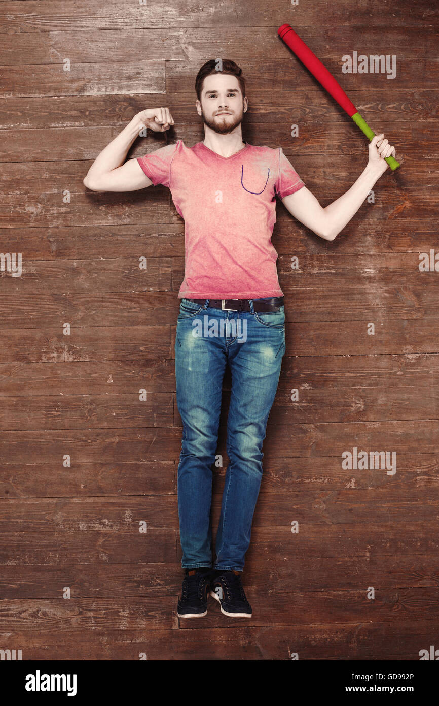 Top view photo of handsome young man on wooden floor. Man holding ...