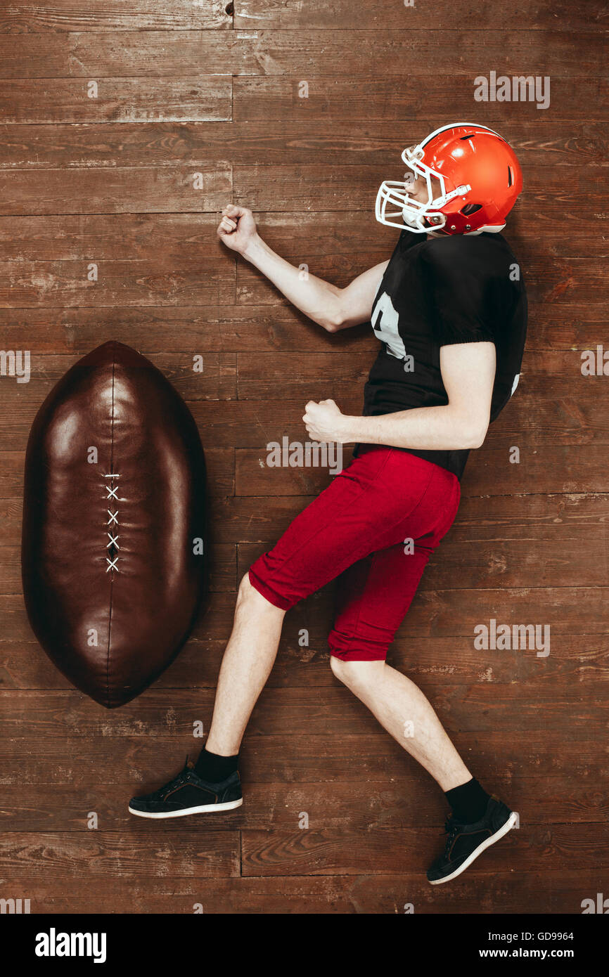 Top view photo of handsome young american football player on wooden ...