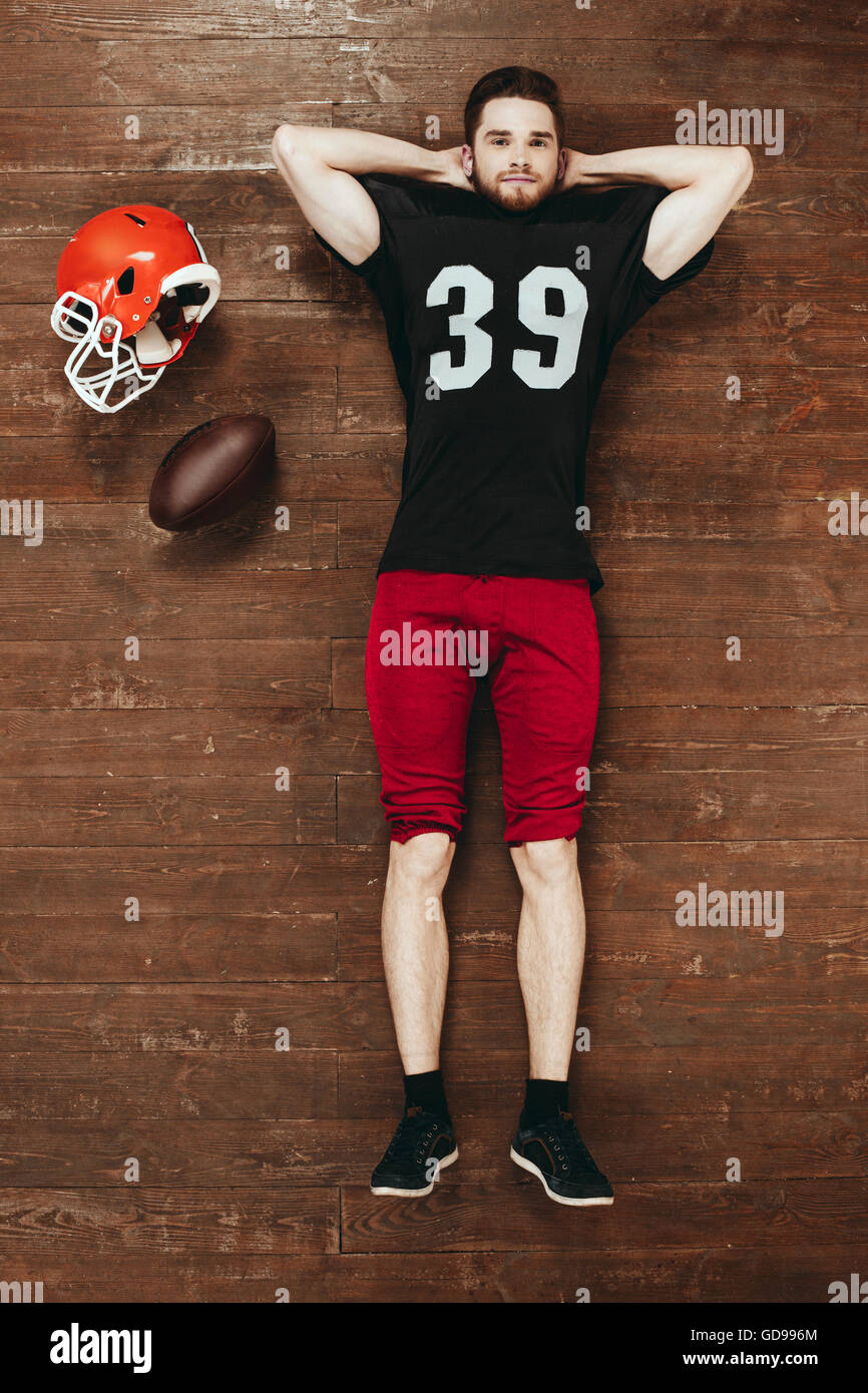 Top view photo of handsome young american football player on wooden ...
