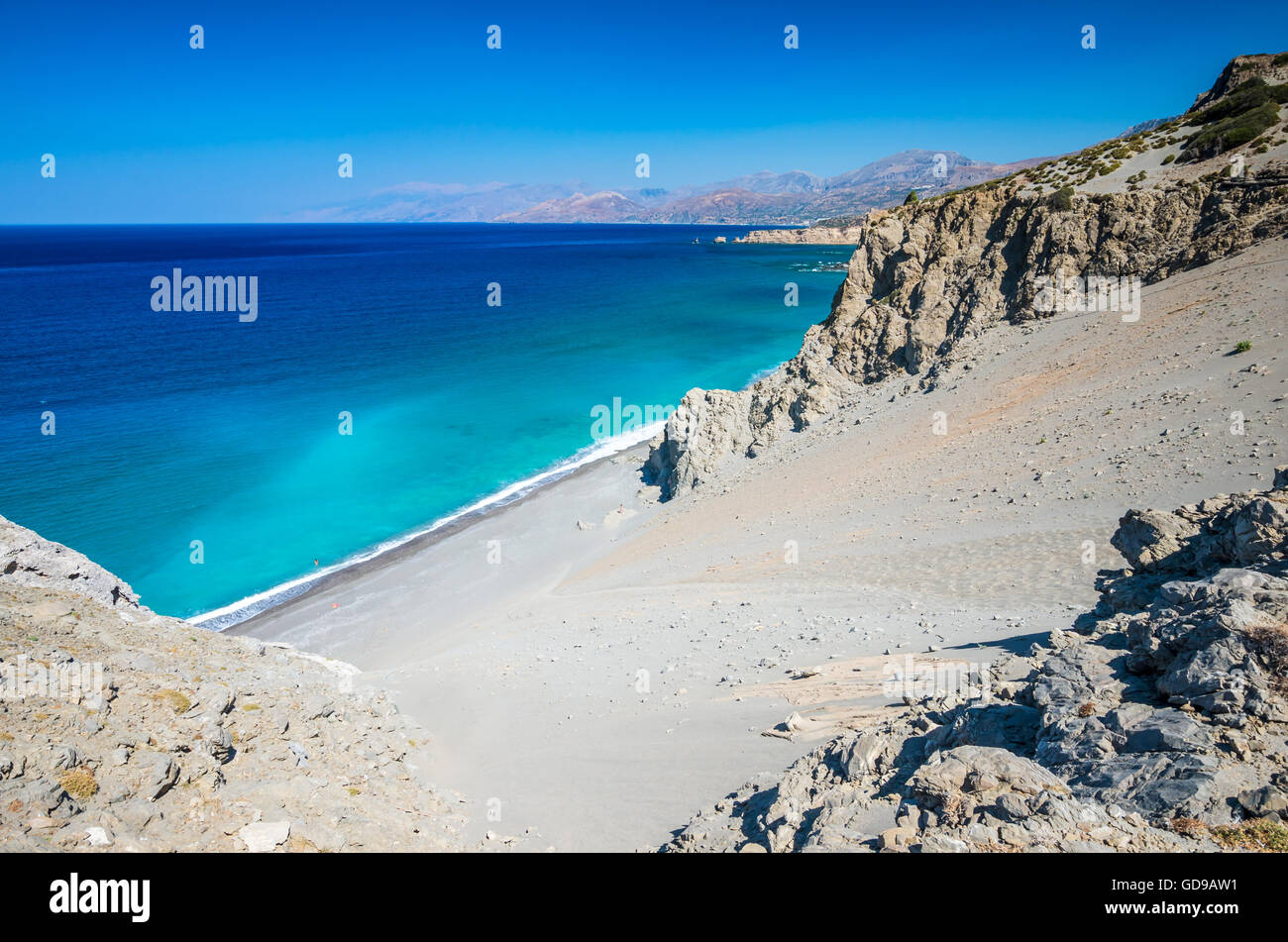 Agios Pavlos Beach in Crete island, Greece. Tourists relax and bath in crystal clear water of St ...