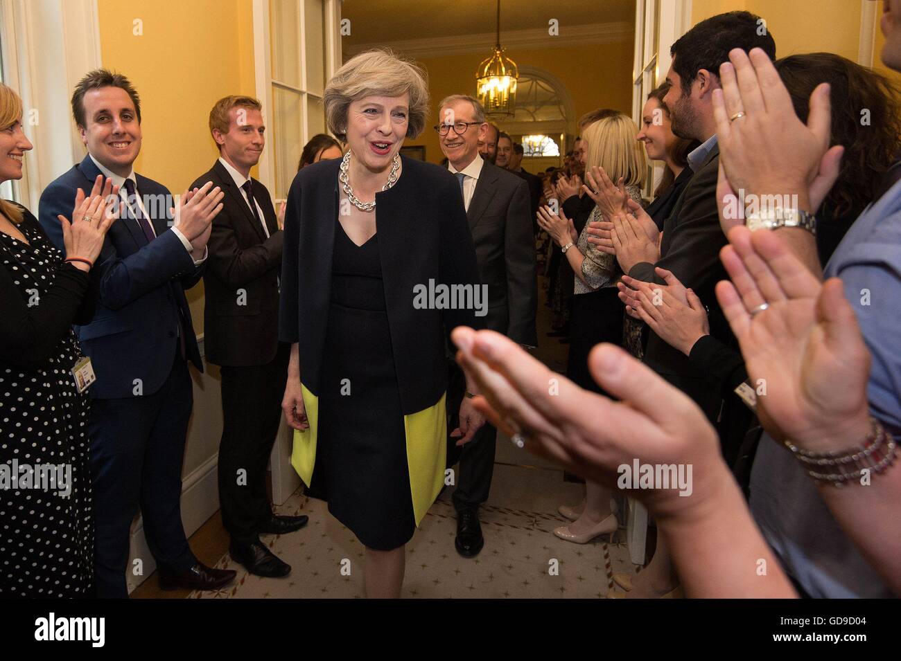Staff clap as new Prime Minister Theresa May, followed by her husband ...