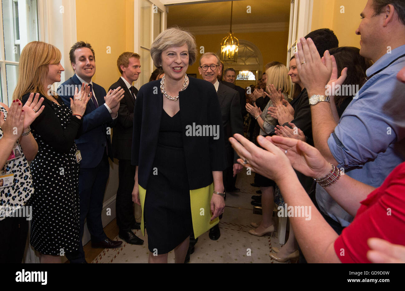 Staff clap as new Prime Minister Theresa May, followed by her husband ...