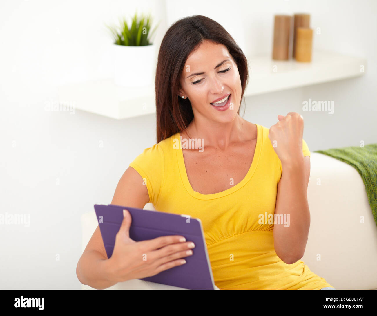 Young woman celebrating being a winner with a victory sign - focus on ...