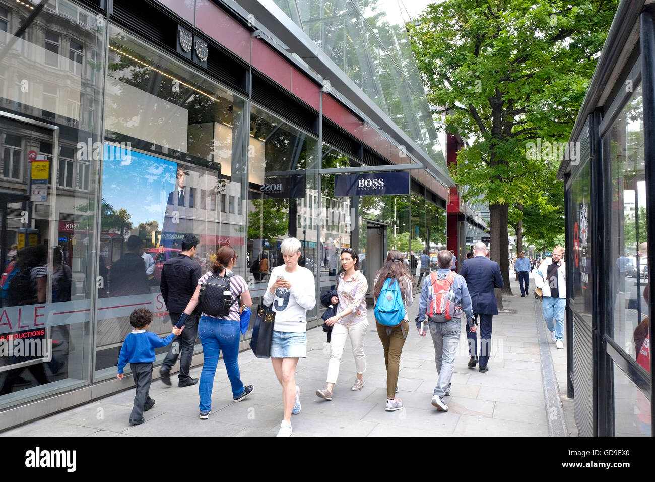 Pedestrians walk past high end retail store Boss in the center of ...
