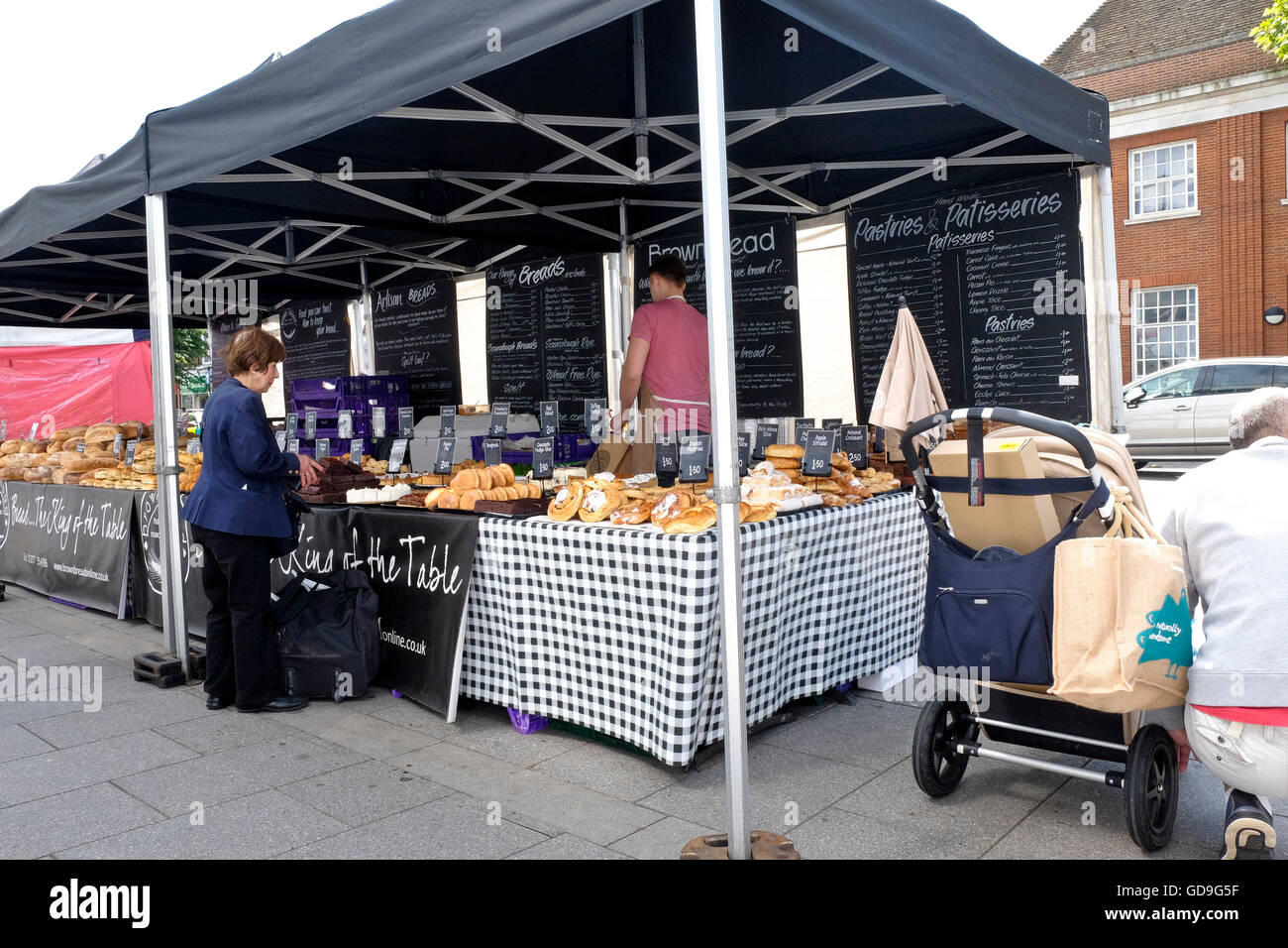 A customer makes a purchase from a stall holder on the pavement in ...