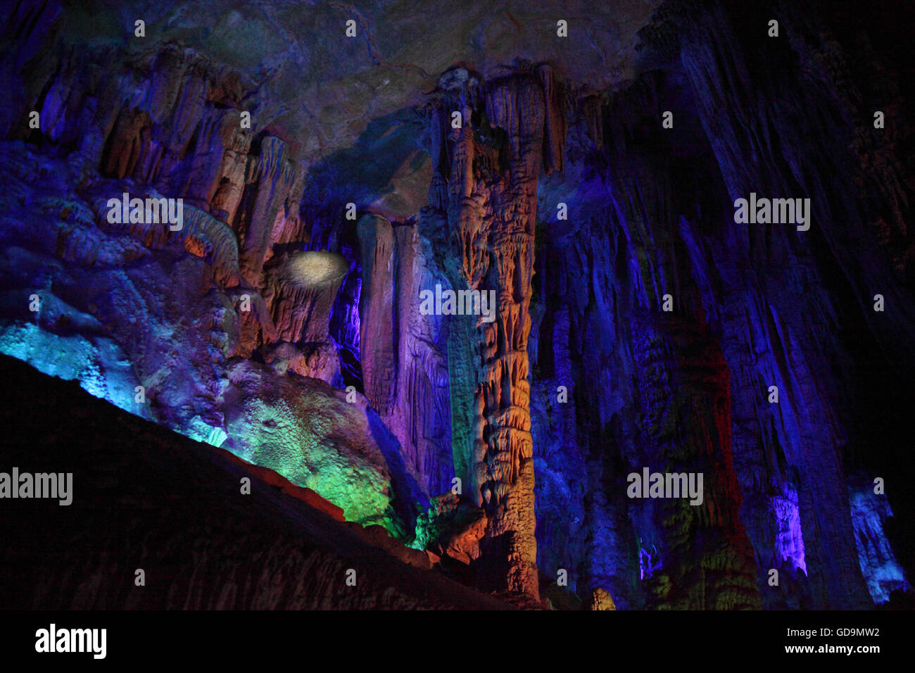 Multicolored lighting illuminating stalactites, stalagmites and ...