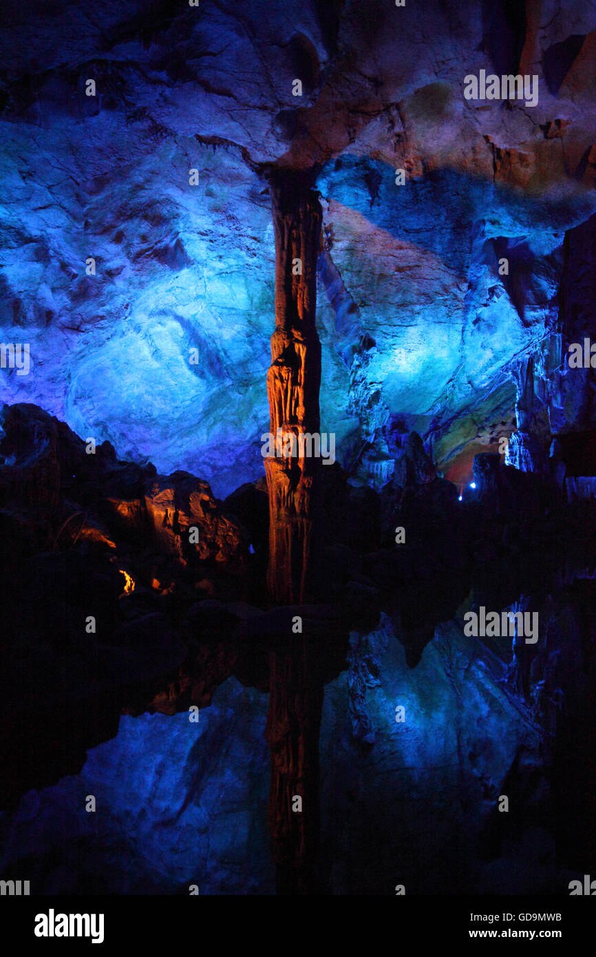 Multicolored lighting illuminating a stalactite and limestone rock ...
