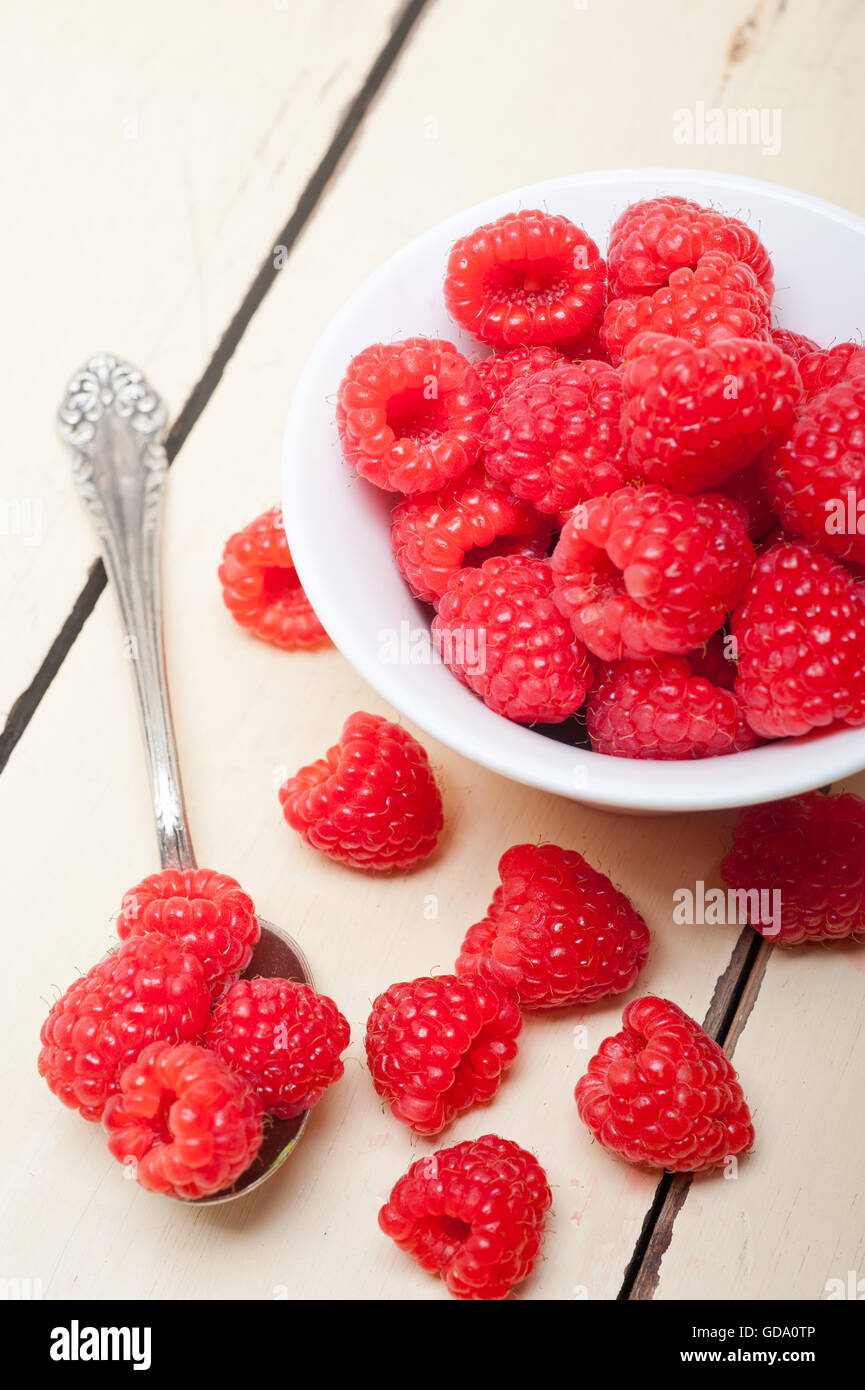 bunch of fresh raspberry on a bowl and white wood rustic table Stock ...
