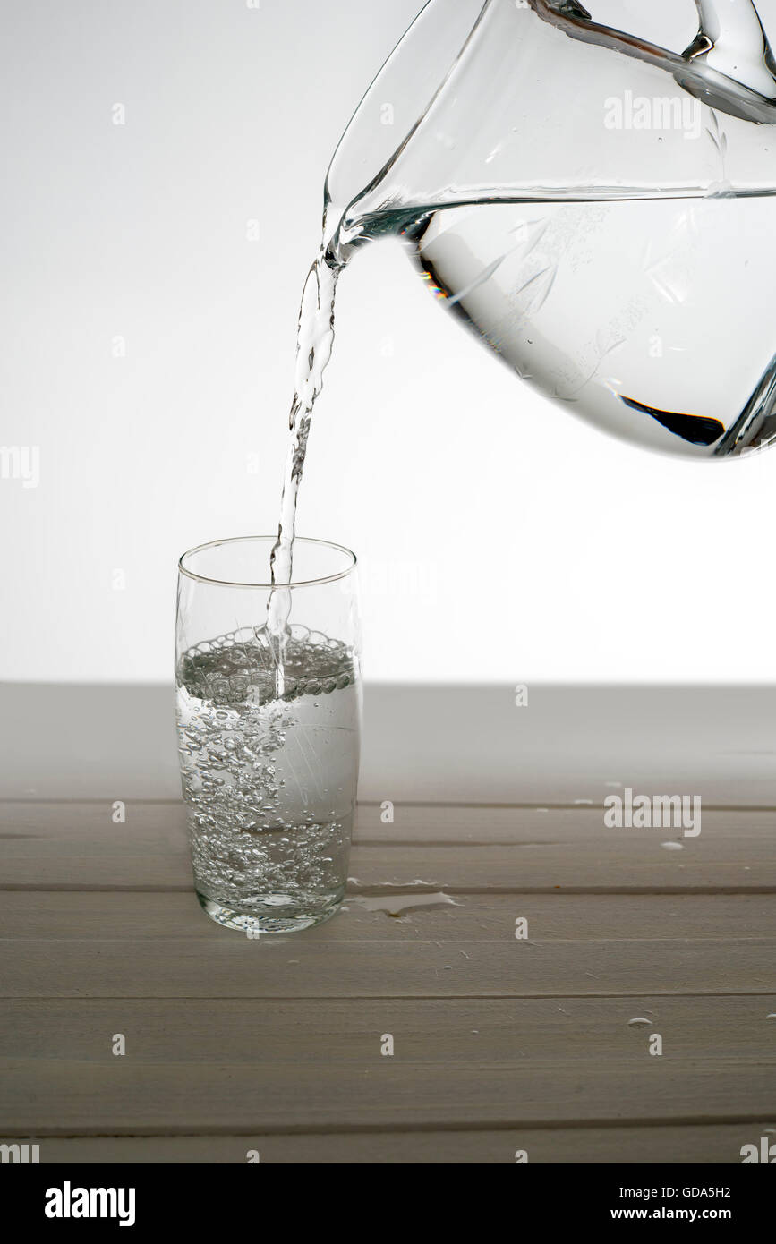 Pour water from a pitcher into a glass. Copy space Stock Photo - Alamy