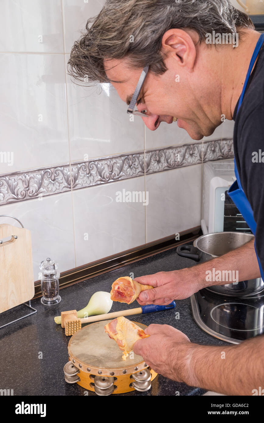 Male cooking, using chicken drumsticks in a somewhat different way ...