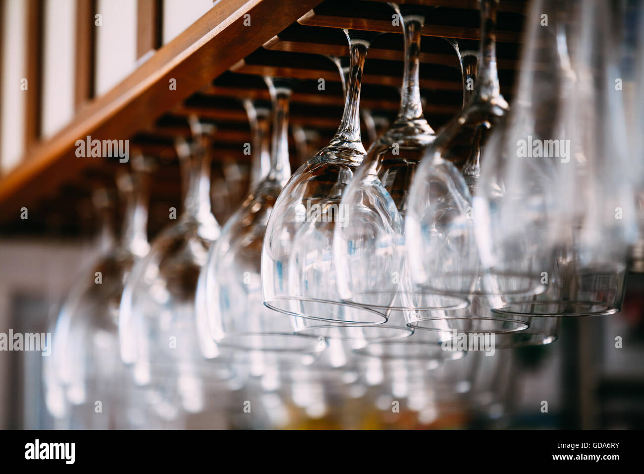 Glasses hanging over bar rack. Empty glasses for wine above a bar rack ...
