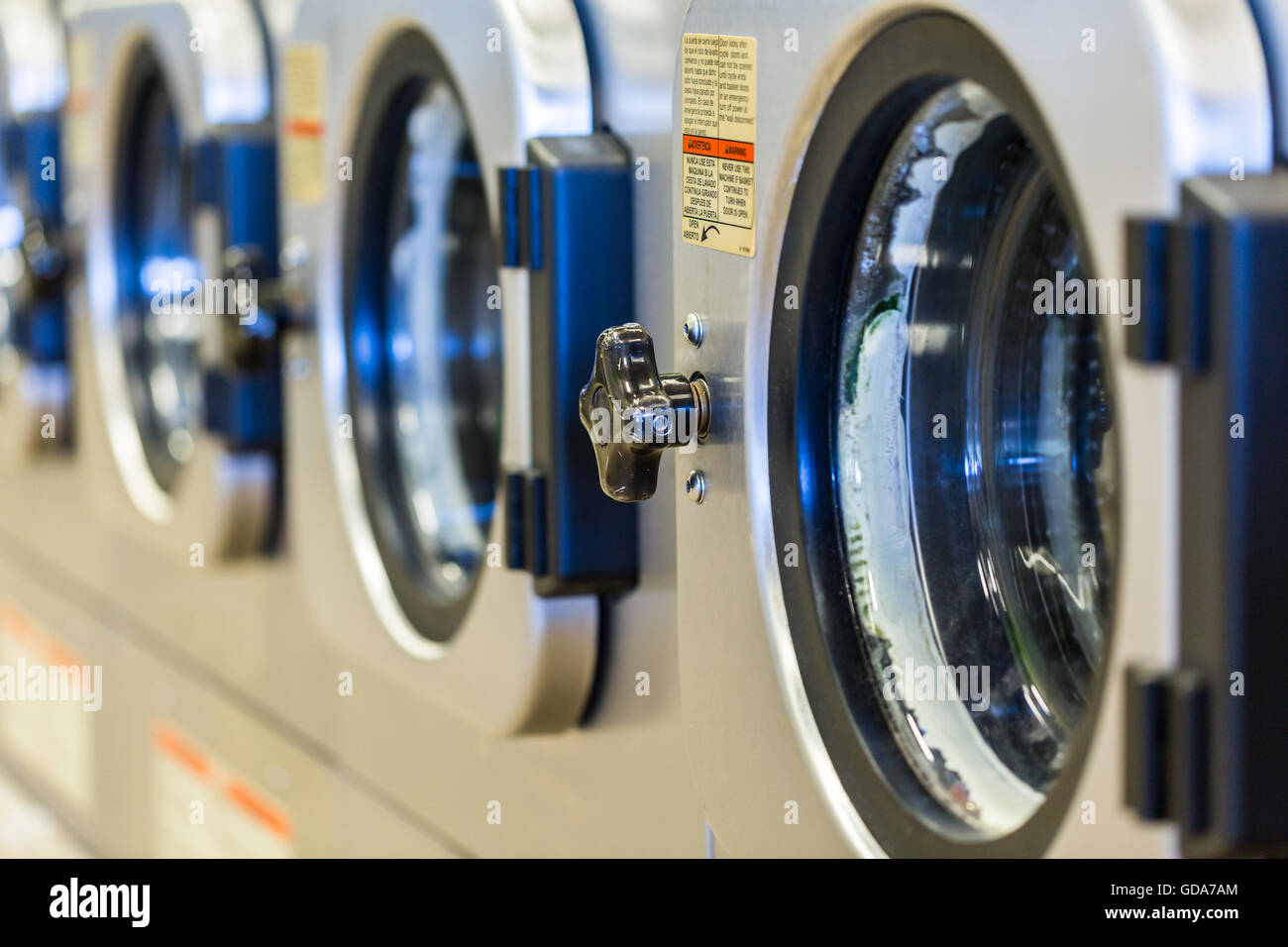Industrial washing machines in a public laundromat Stock Photo - Alamy
