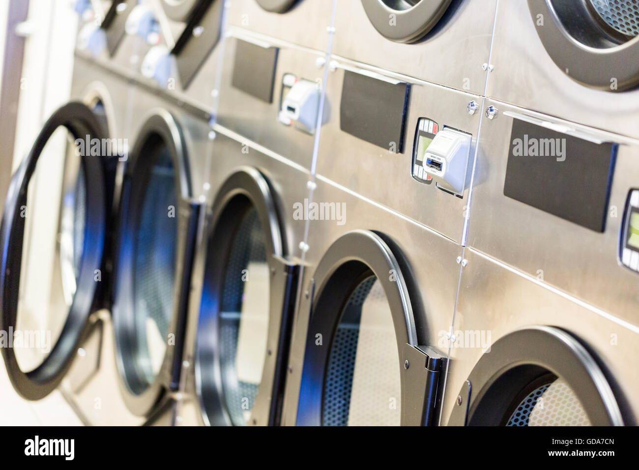 Industrial washing machines in a public laundromat Stock Photo - Alamy