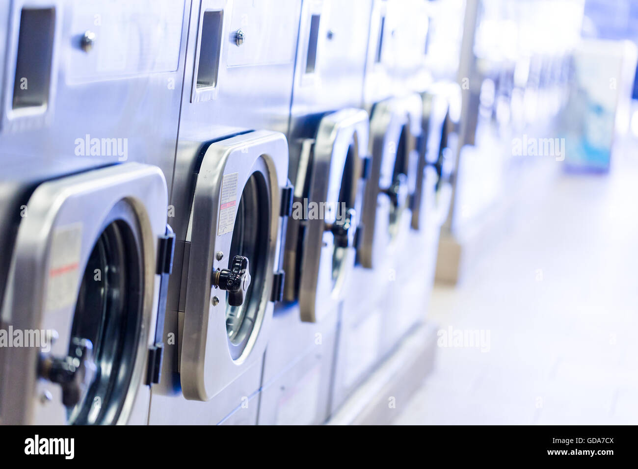 Industrial washing machines in a public laundromat Stock Photo - Alamy