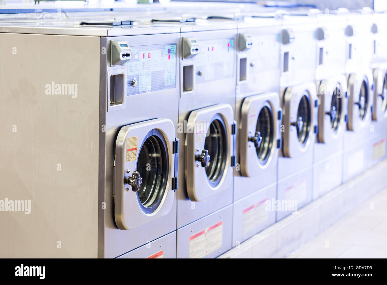 Industrial washing machines in a public laundromat Stock Photo - Alamy