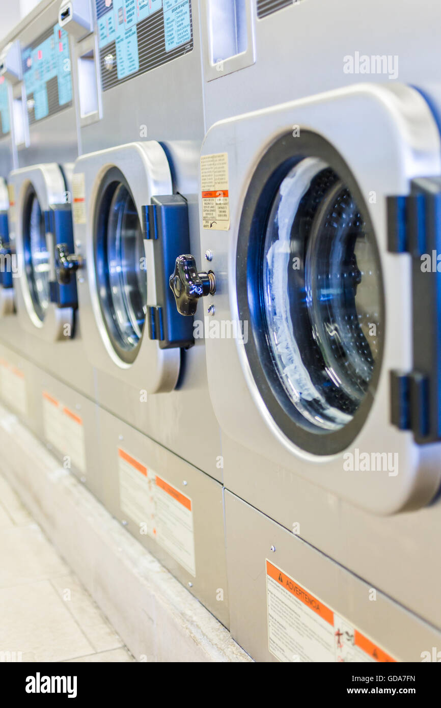 Industrial washing machines in a public laundromat Stock Photo - Alamy