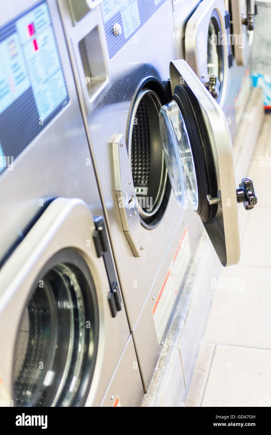Industrial washing machines in a public laundromat Stock Photo - Alamy