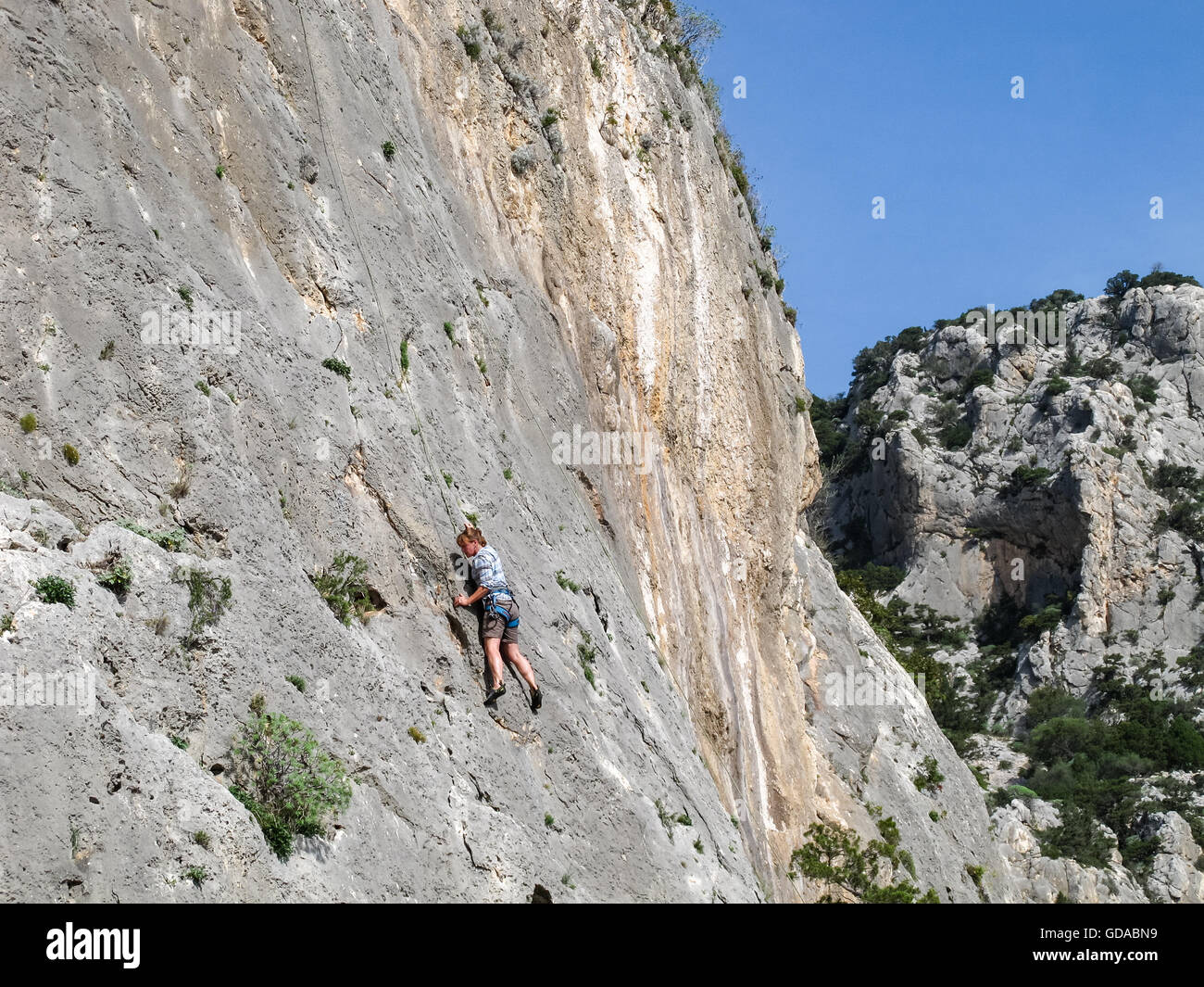 Italy, Sardinia, Climber on a steep cliff wall, rock wall with climber ...