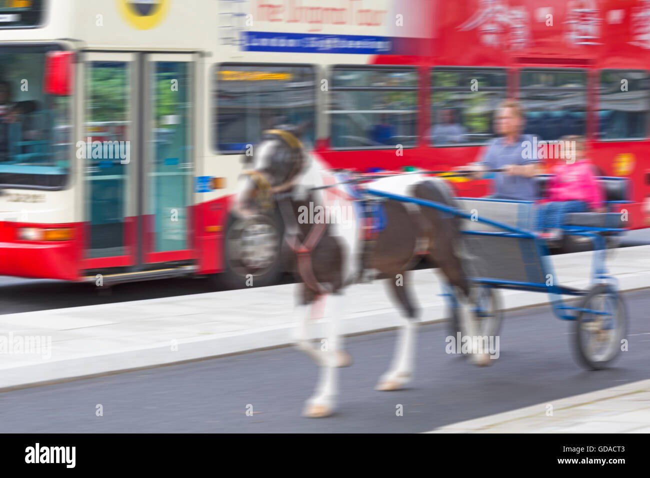 Horse and cart racing with double decker bus at London in July - motion ...