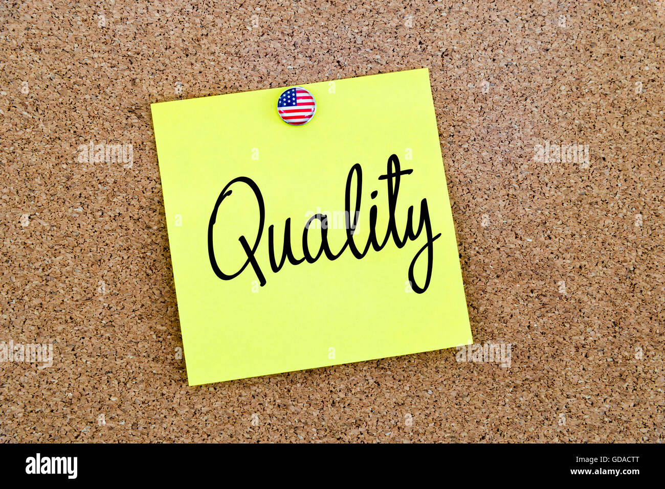 Written text Quality over yellow paper note pinned on cork board Stock ...
