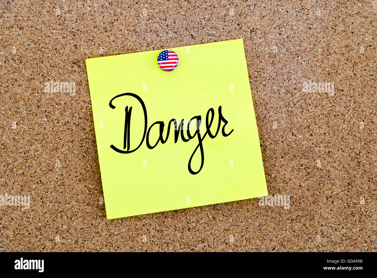 Written text Danger over yellow paper note pinned on cork board Stock ...
