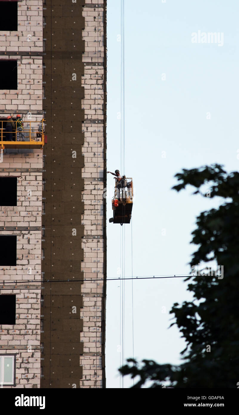 construction suspended cradle with worker on a newly built high-rise ...