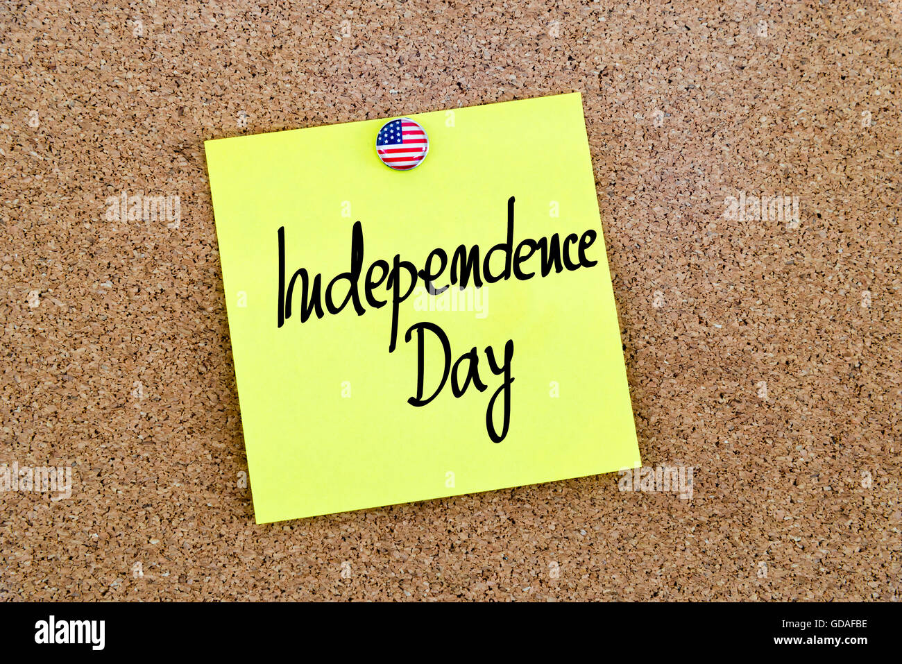 Written text Independence Day over yellow paper note pinned on cork ...