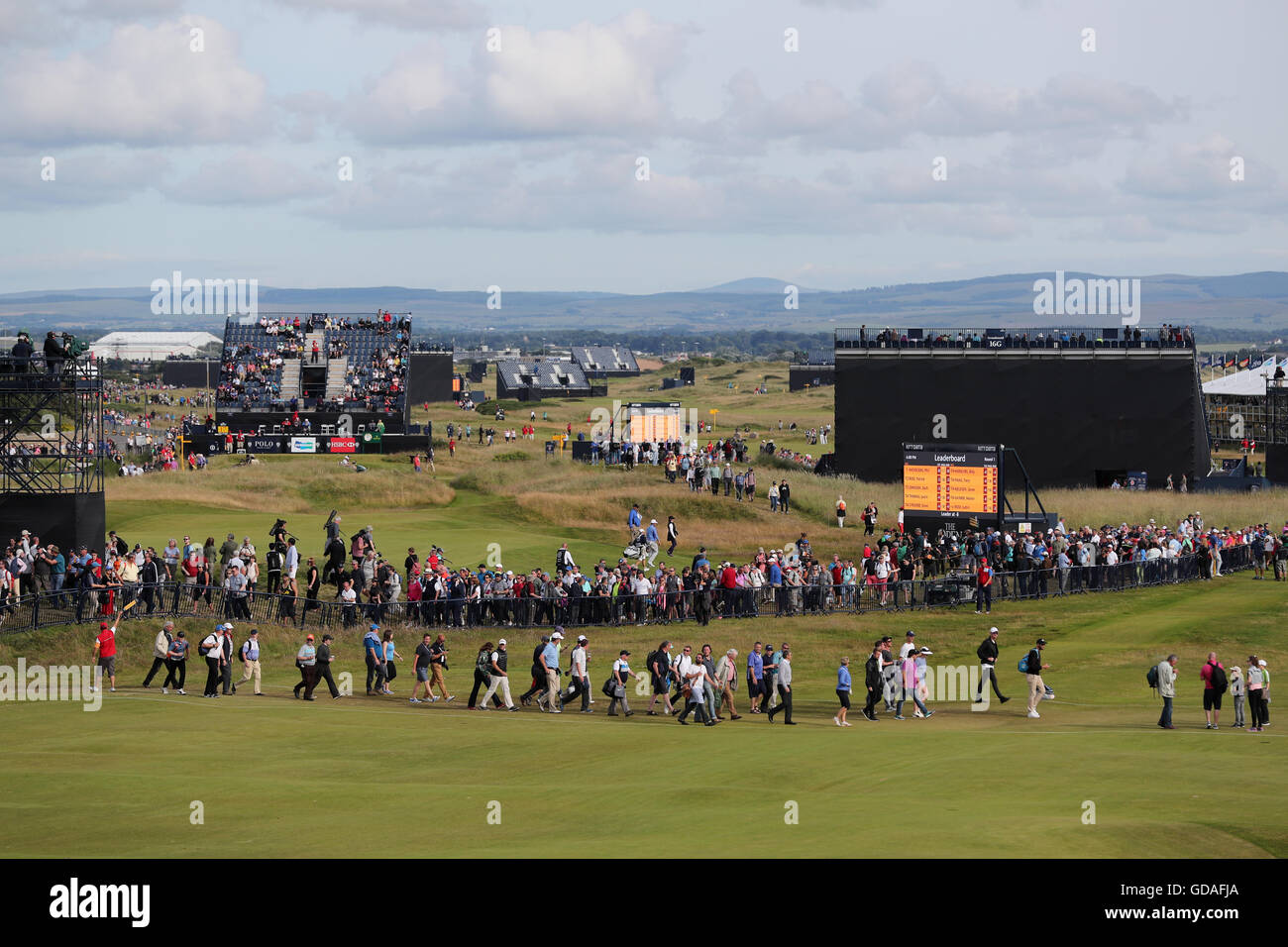 Crowds walk over across the 18th fairway during day one of The Open ...