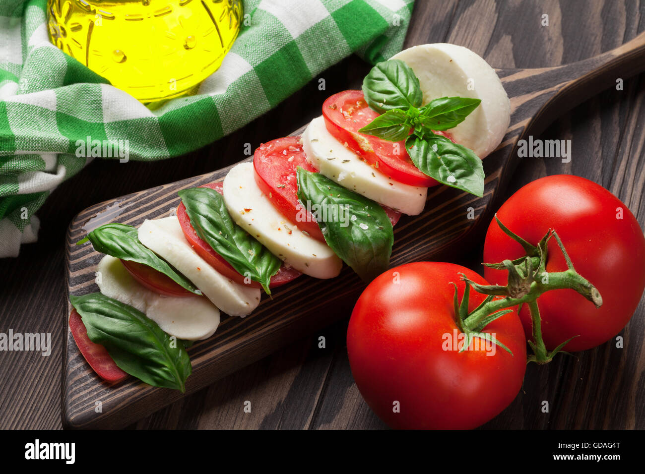 Caprese salad. Mozzarella cheese, tomatoes and basil herb leaves on ...