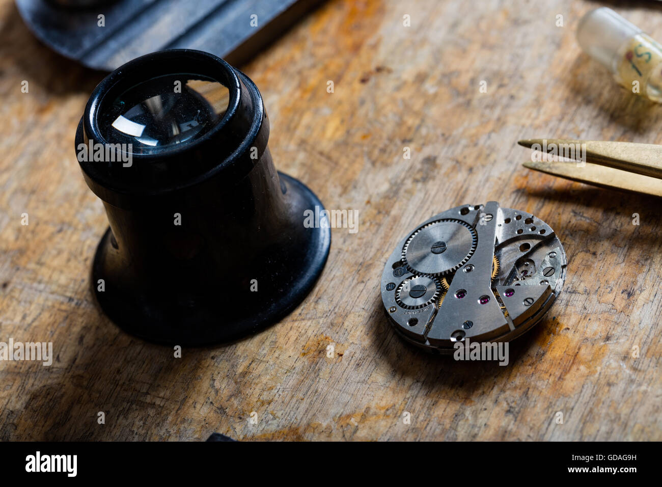 Watchmaker or horologists work bench with a loupe magnifier, tweezers ...