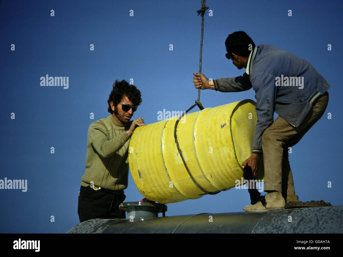 Iraqi workers priming an oil pipeline pump in the desert Stock Photo ...