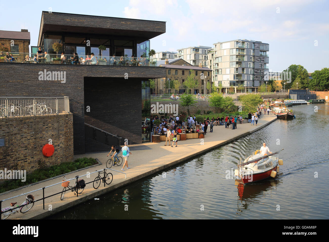 A boat sailing down the Regents Canal, past the Lighterman gastro-pub ...