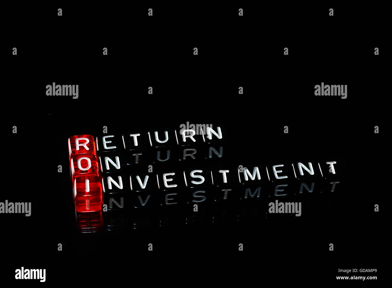 ROI Return On Investment written on cubes on black background Stock ...
