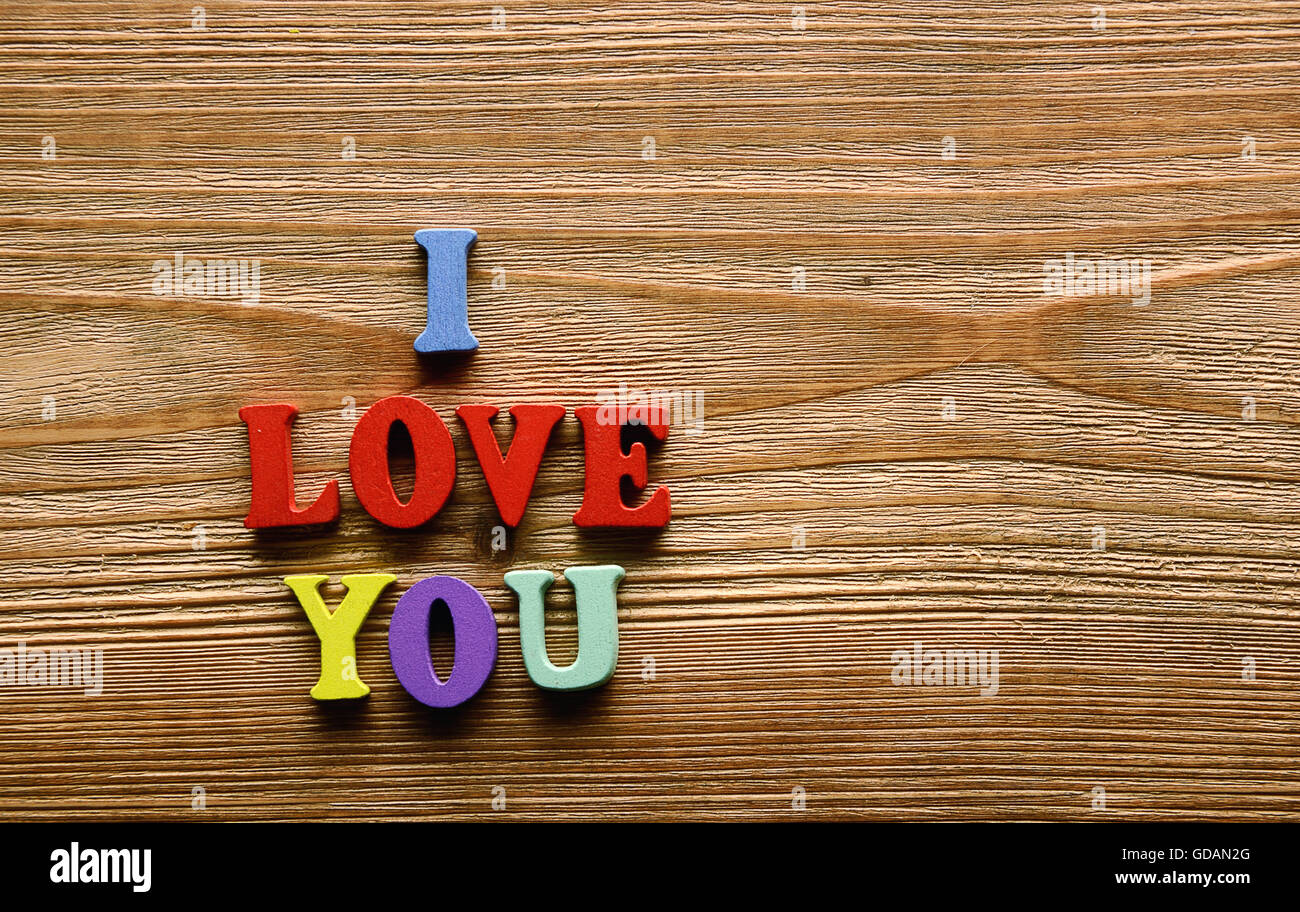I LOVE YOU- word made from multicolored letters on wooden background ...