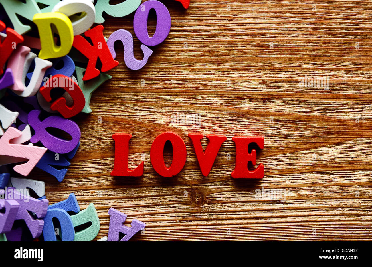 LOVE- word made from multicolored letters on wooden background warm ...