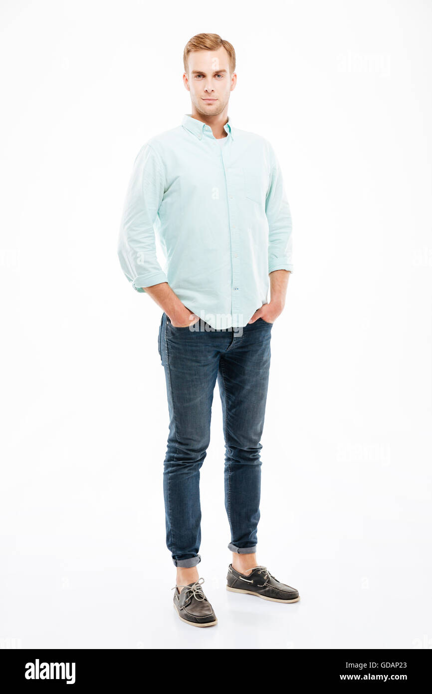 Full length of confident handsome young man standing with hands in ...