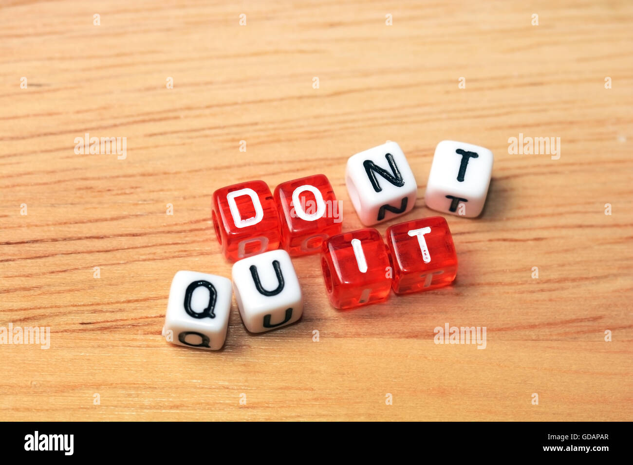 Dont Quit Do It written on red and white dices on wooden background ...