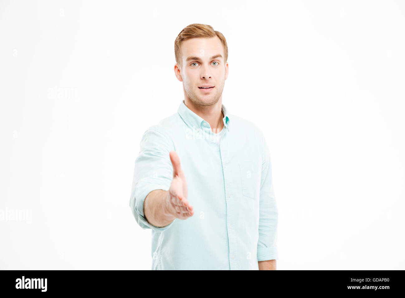 Attractive young businessman standing and giving his hand for handshake ...