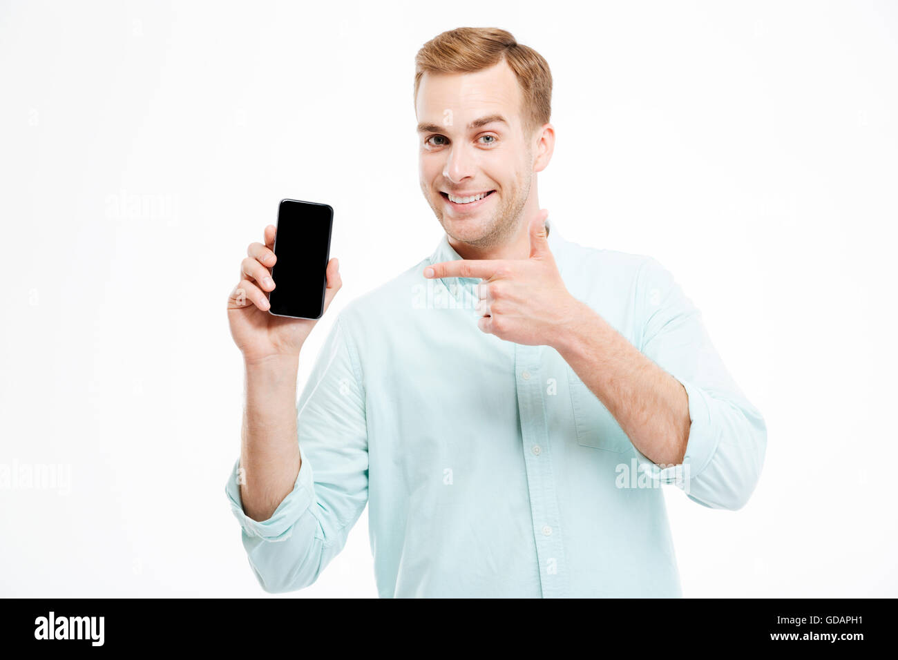Cheerful confident young man showing blank screen mobile phone over ...