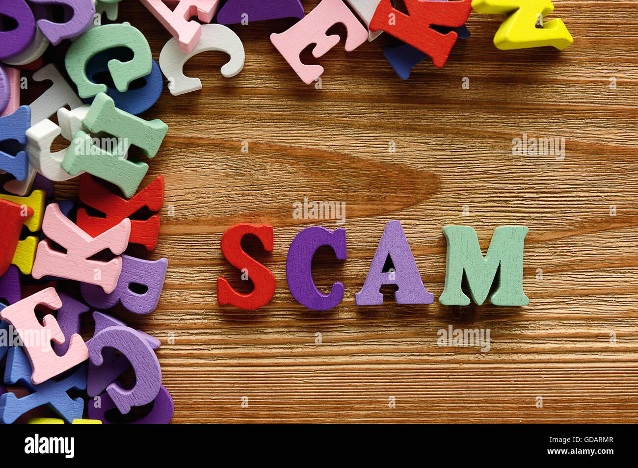 SCAM - words made from multicolored letters on wooden background Stock ...