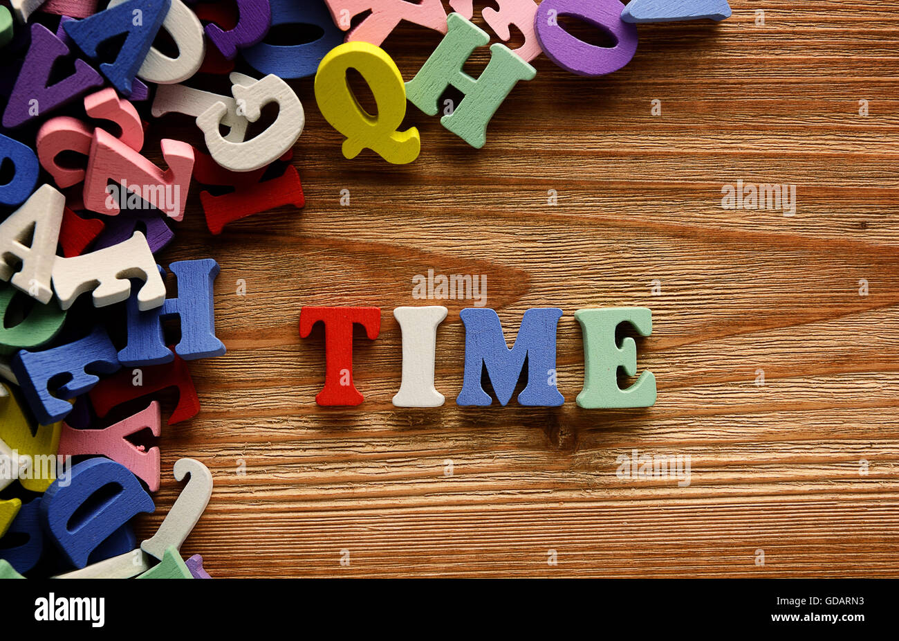 TIME - words made from multicolored letters on wooden background Stock ...