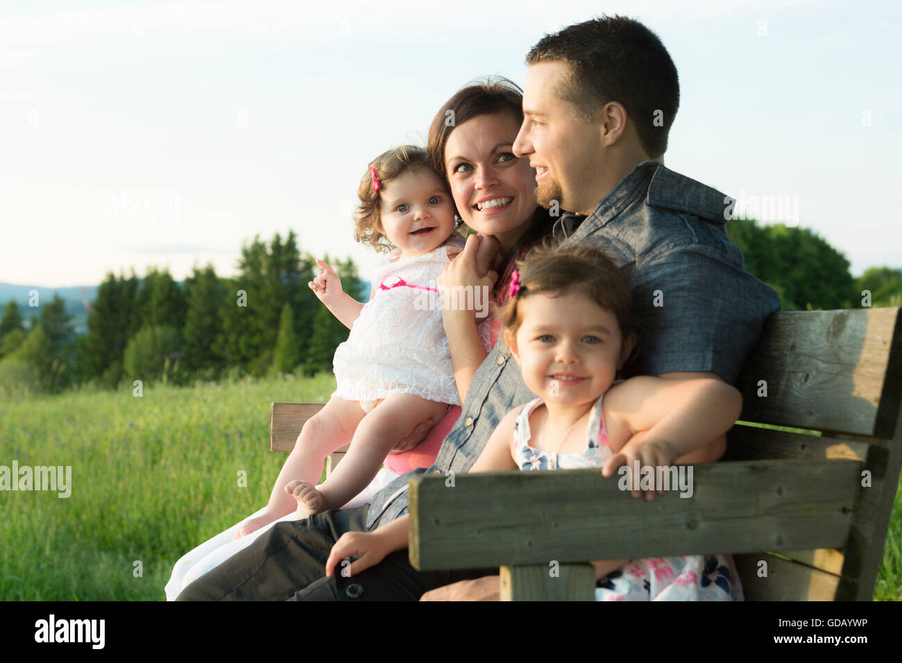 family sit on bench at sunset Stock Photo - Alamy