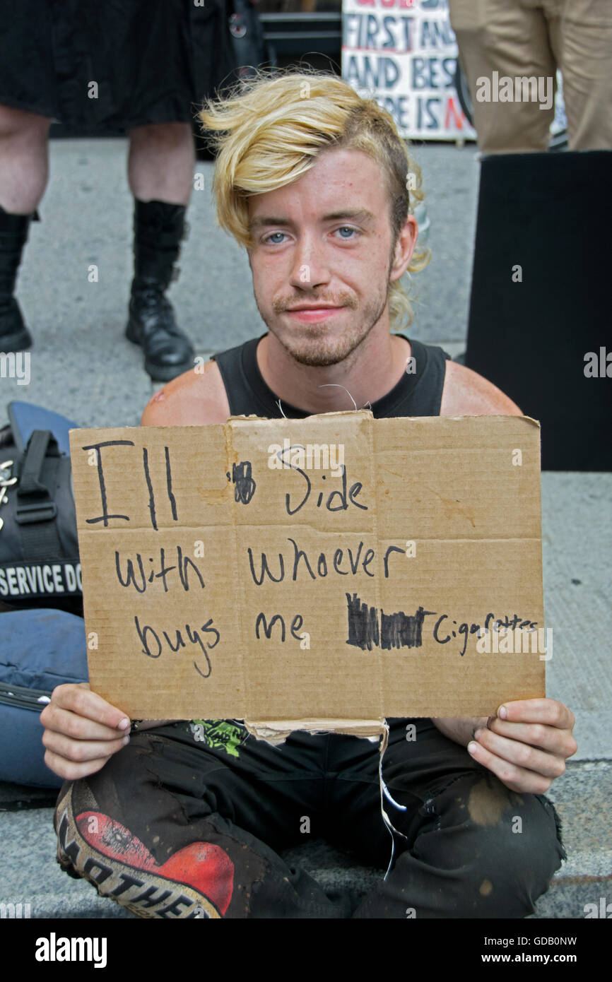 A young man with a funny sign pledging to support anyone who will buy ...